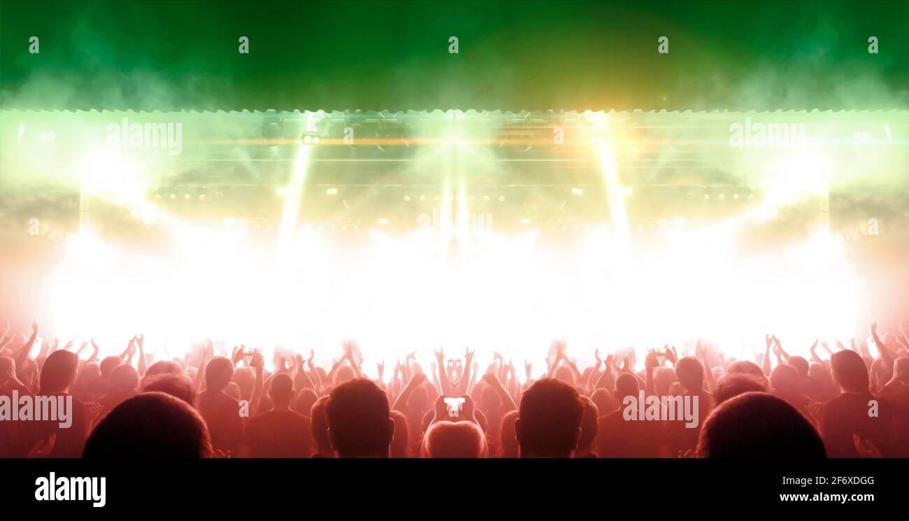 Large gathering of people in front of a lit stage Stock Photo - Alamy
