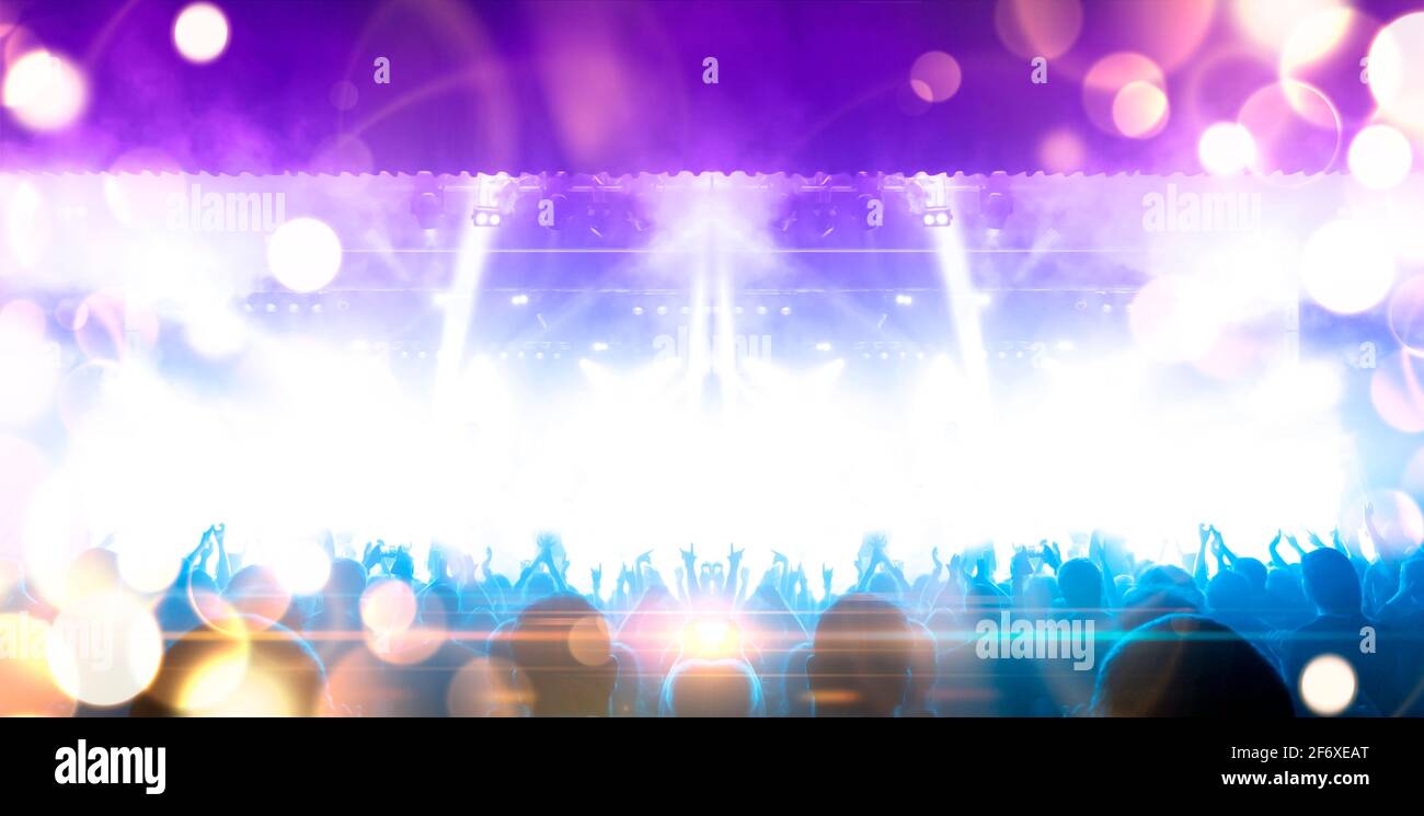 Large gathering of people in front of a lit stage Stock Photo - Alamy