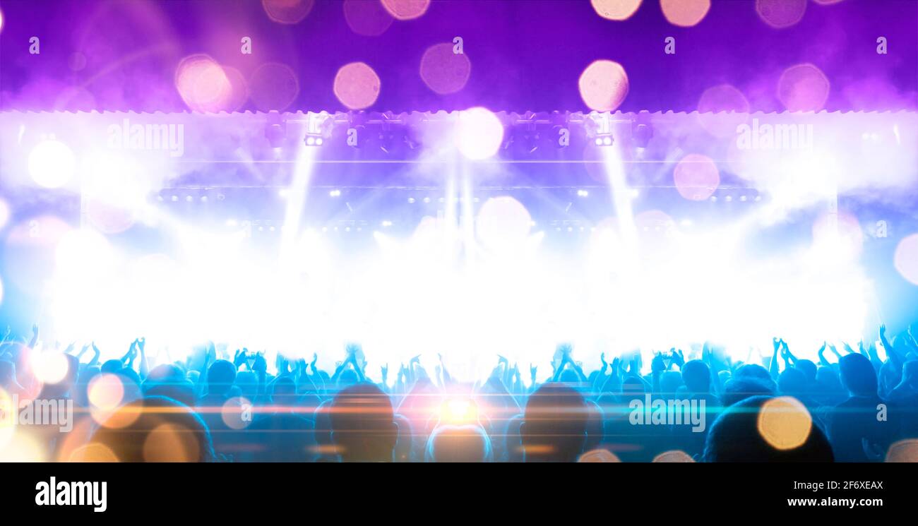Large gathering of people in front of a lit stage Stock Photo - Alamy