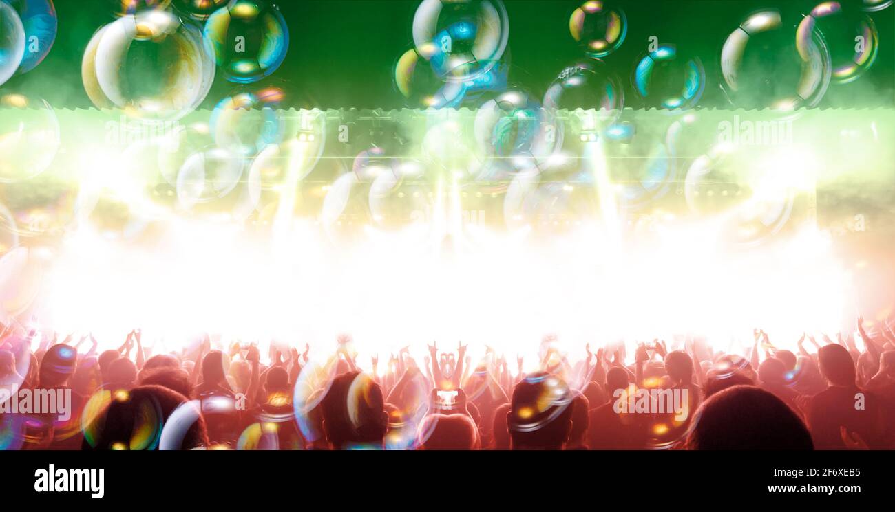 Large gathering of people in front of a lit stage Stock Photo - Alamy