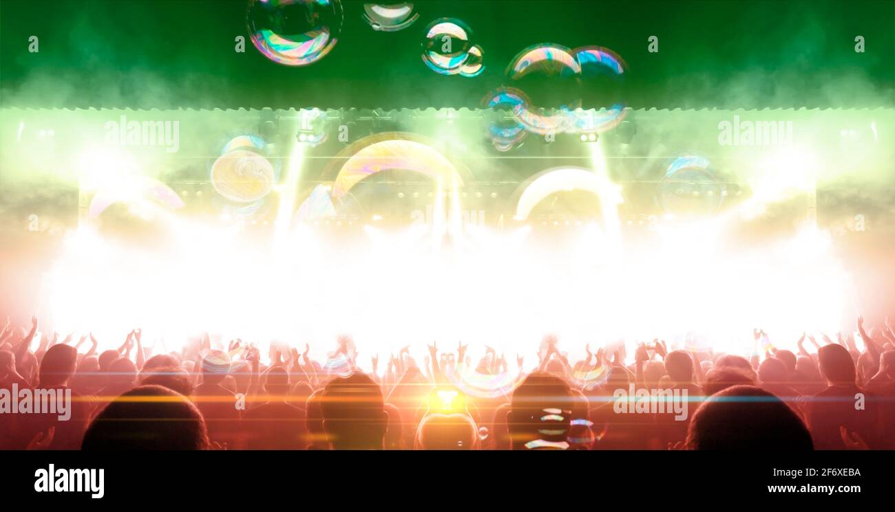 Large gathering of people in front of a lit stage Stock Photo - Alamy