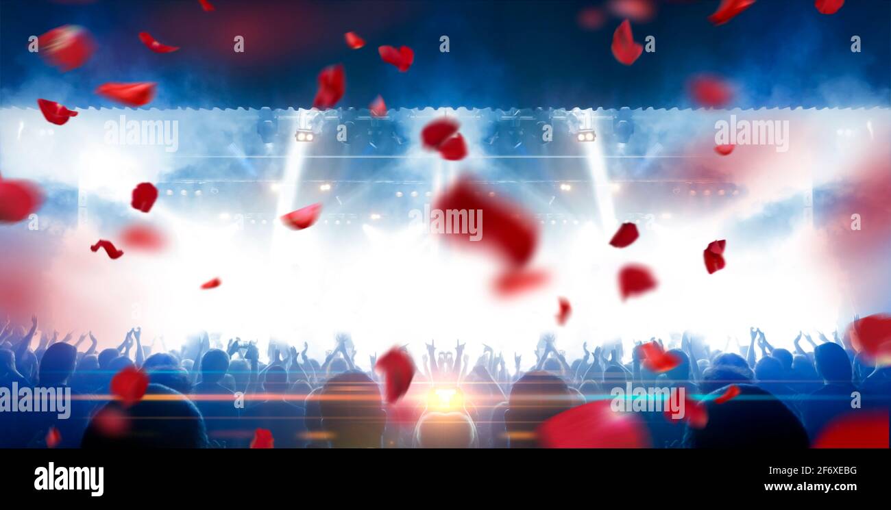 Large gathering of people in front of a lit stage Stock Photo - Alamy