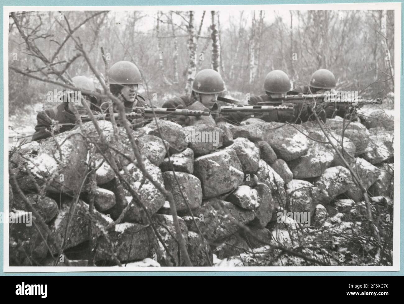 Men behind stone wall Stock Photo - Alamy