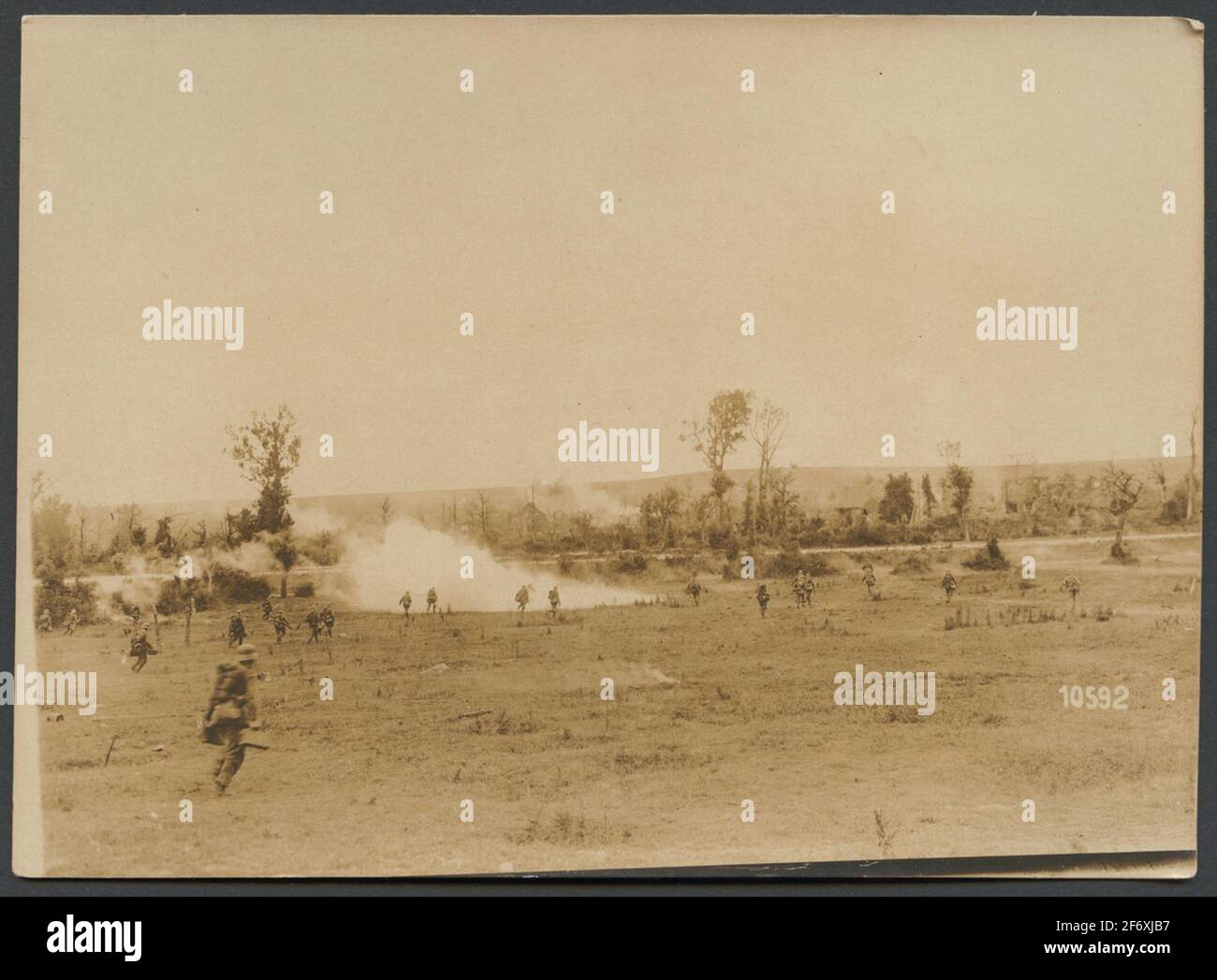 The picture shows soldiers running over a field where there are several ...