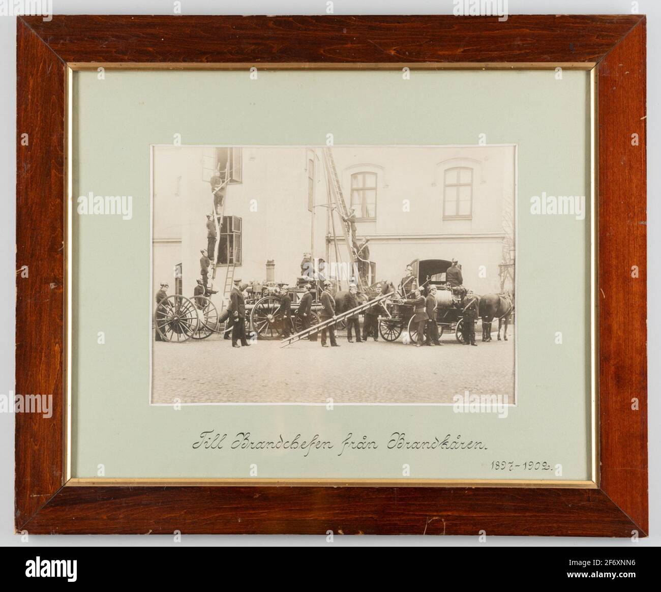 The picture shows a fire department with horse-drawn fire trolley and ...