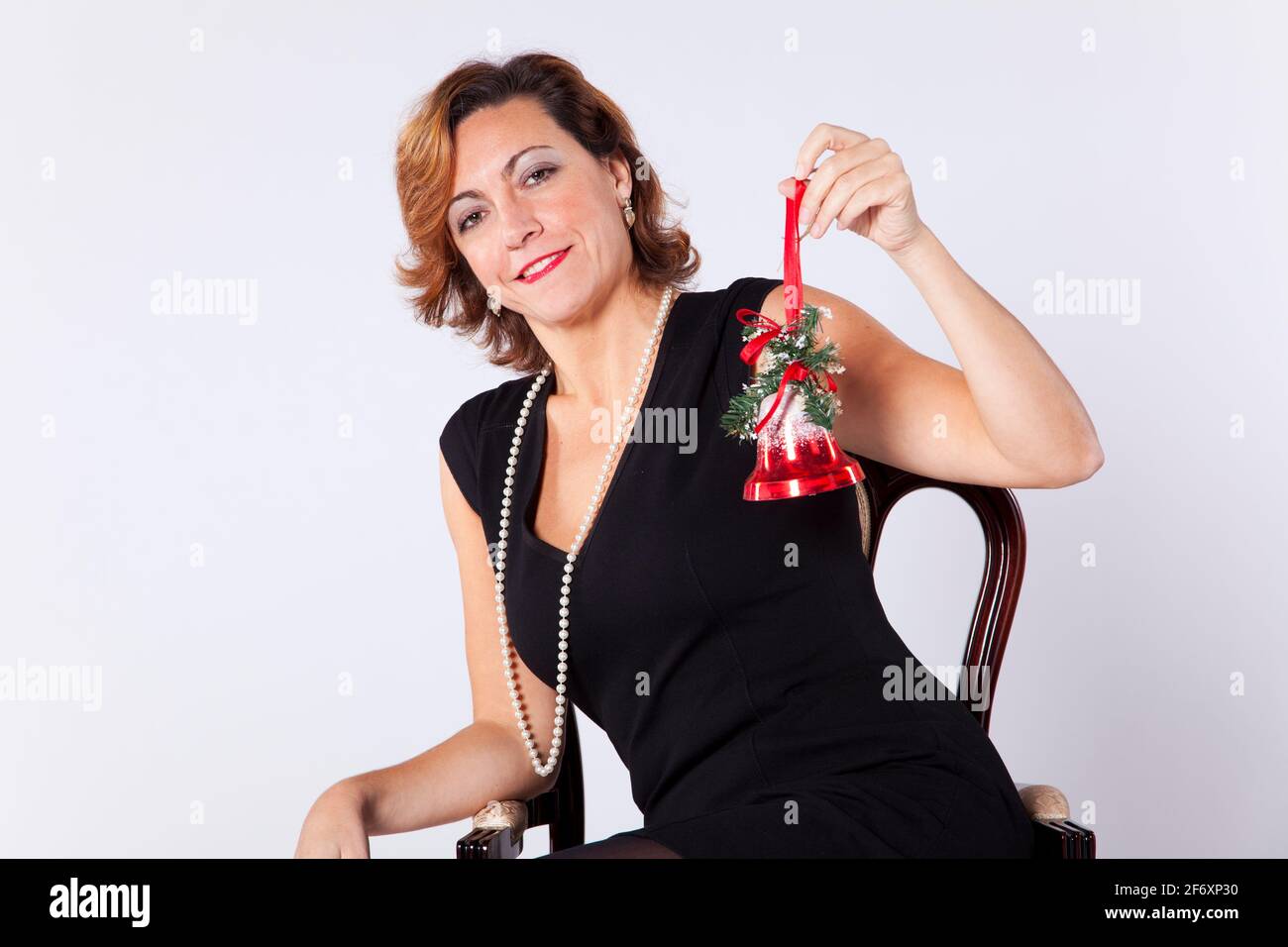 Woman sited on a chair holding a christmas bell Stock Photo - Alamy
