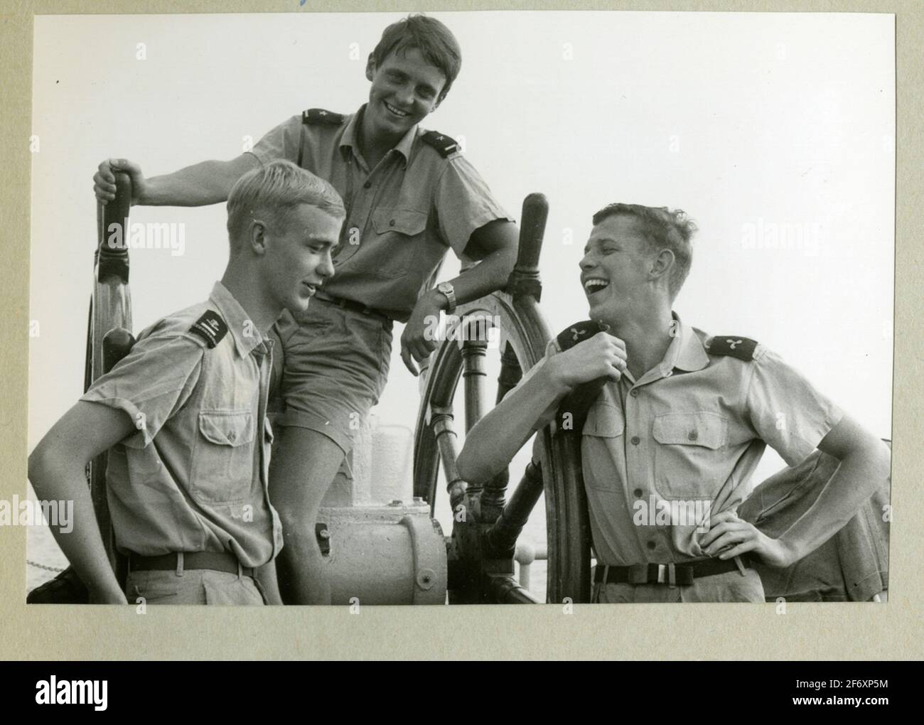 The picture represents three crew members in uniform on board the ...