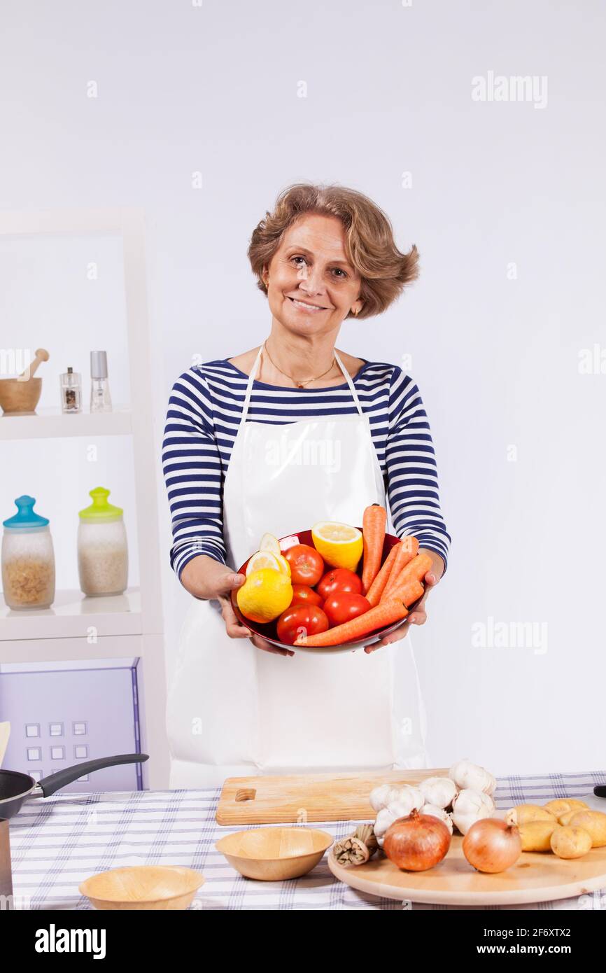 Beautiful and happy senior woman cooking at her kitchen Stock Photo - Alamy