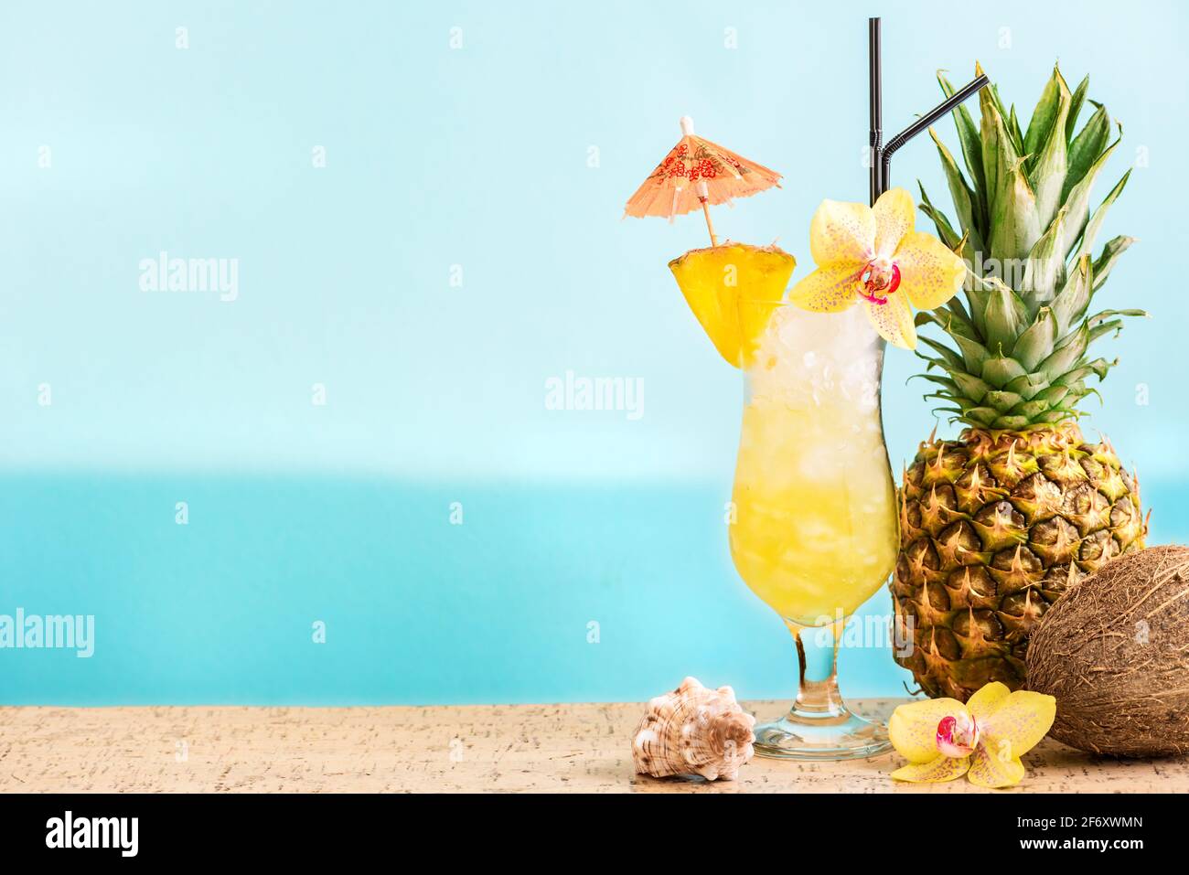 Summer tropical cocktail drink, fruits and flowers, blue sea background ...