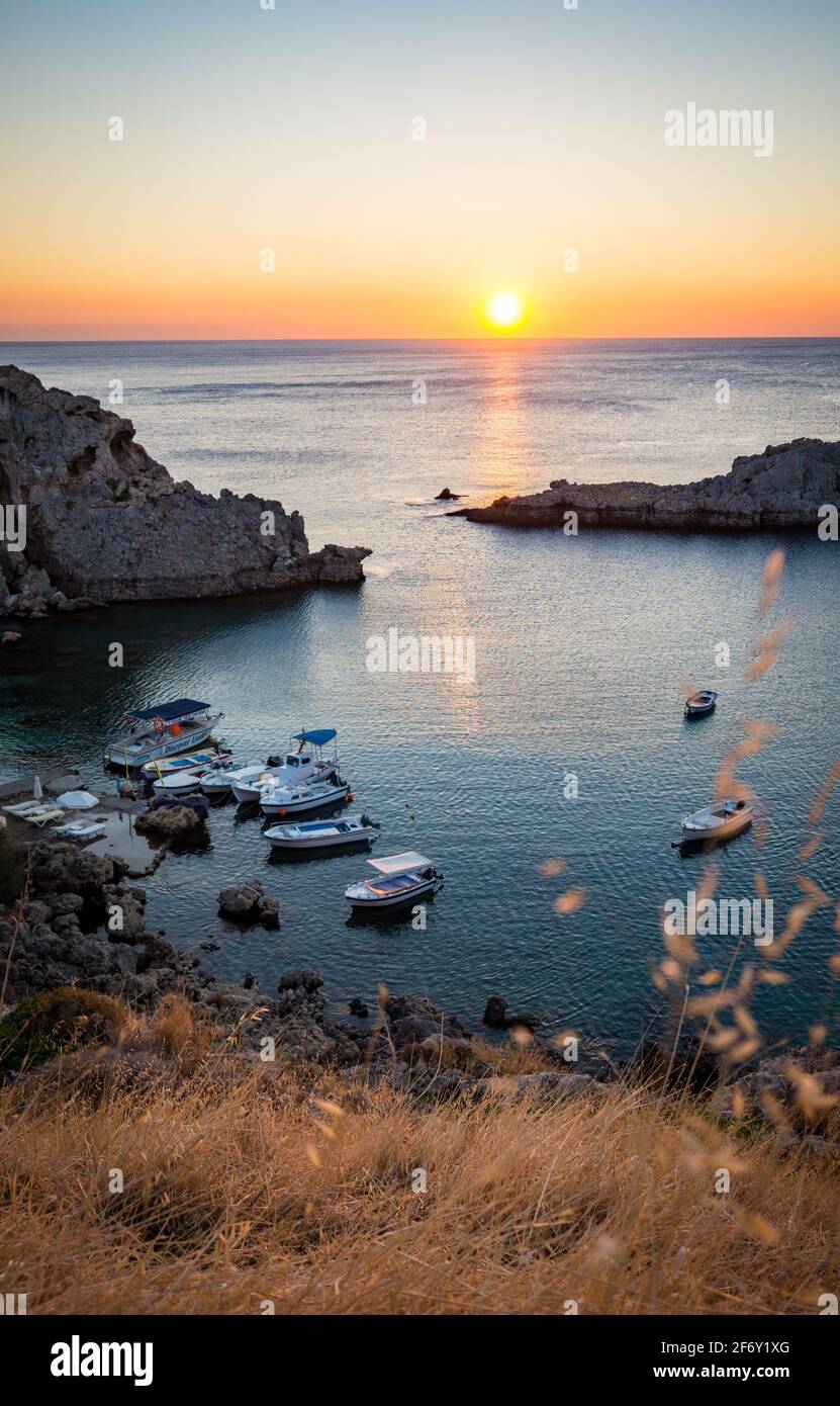 Saint Paul's Bay beach with boats in Lindos, Rhodes, Greece at sunrise ...