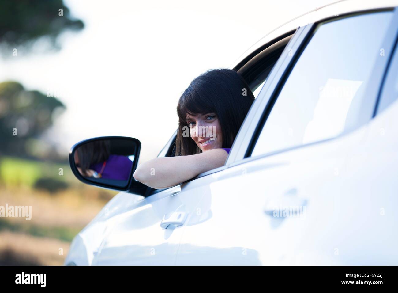Woman driving and looking outside the car window Stock Photo - Alamy