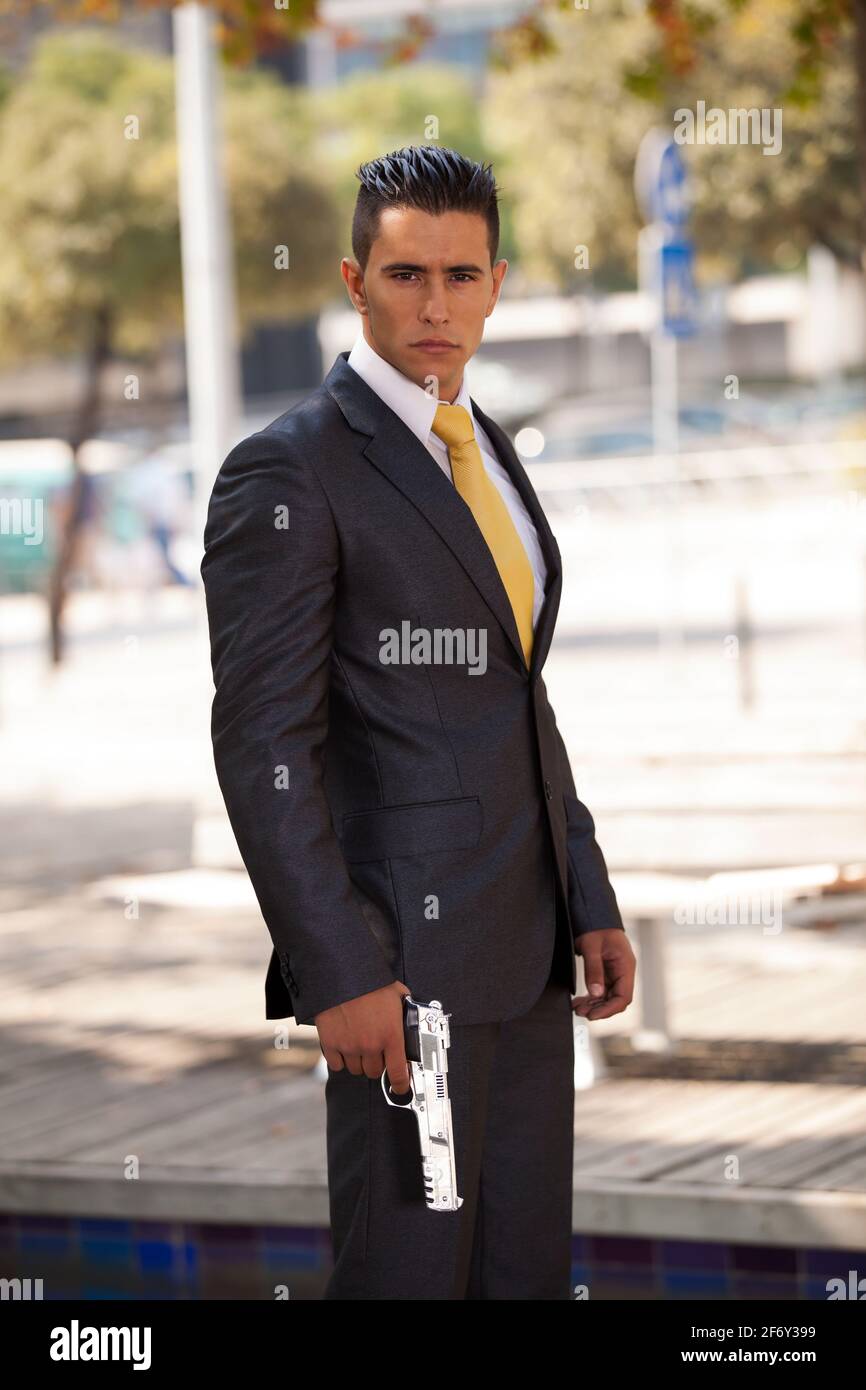 Powerful businessman with a gun on his hand Stock Photo - Alamy