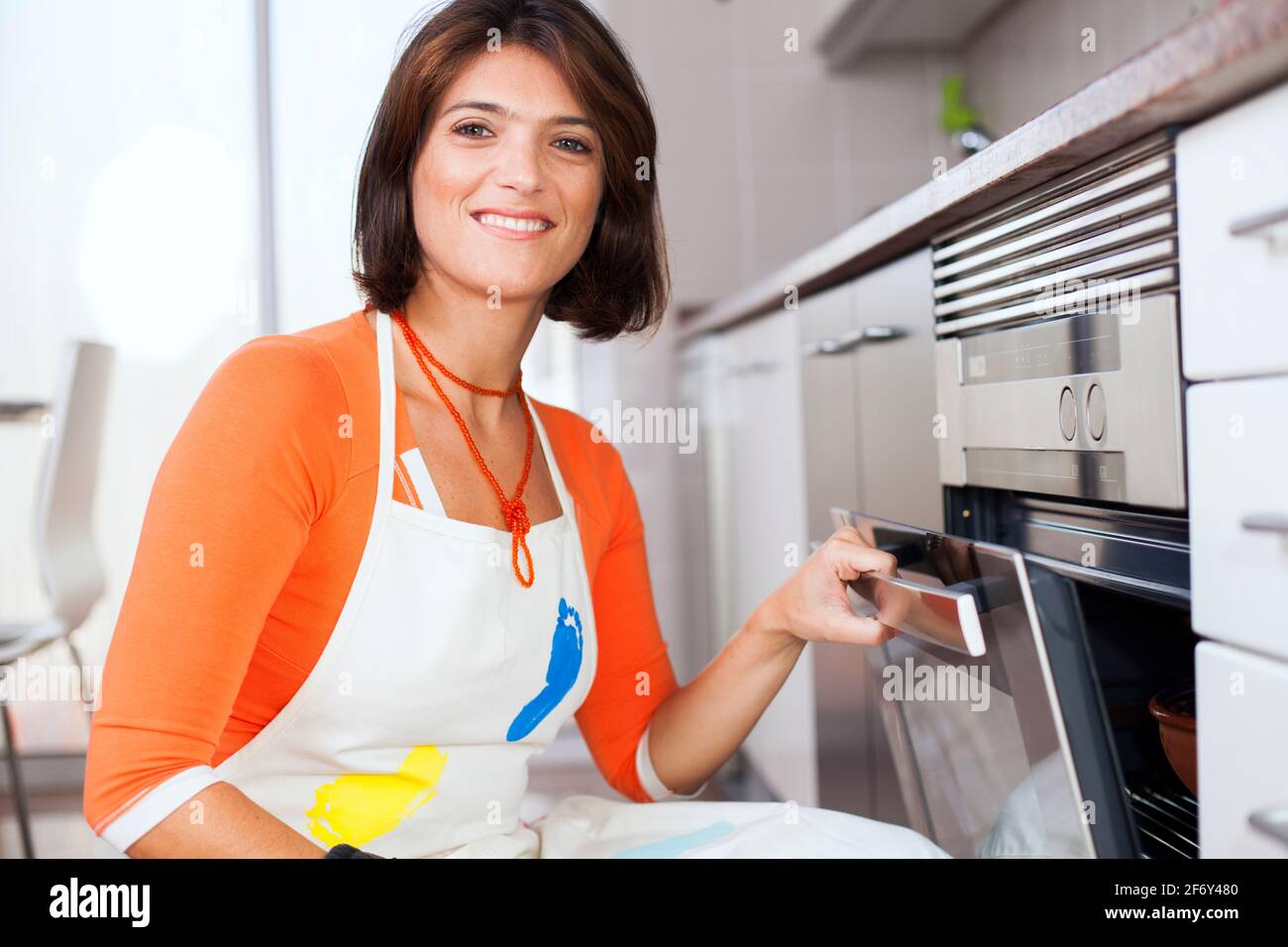 modern woman taken the food out of the kitchen oven Stock Photo - Alamy