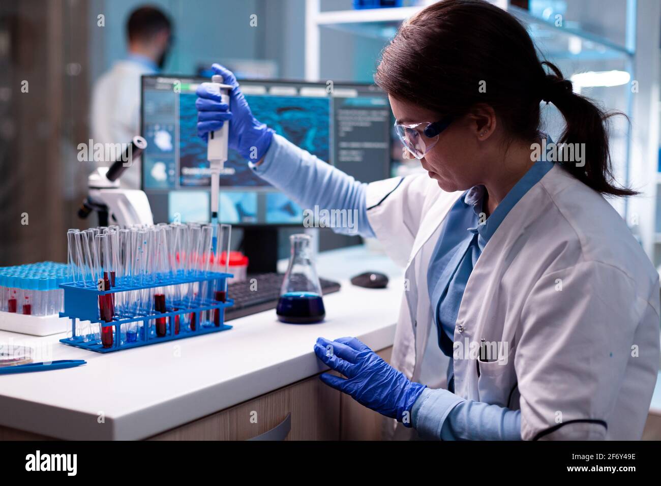 Scientist looking into micropipette for biology test, science disease ...