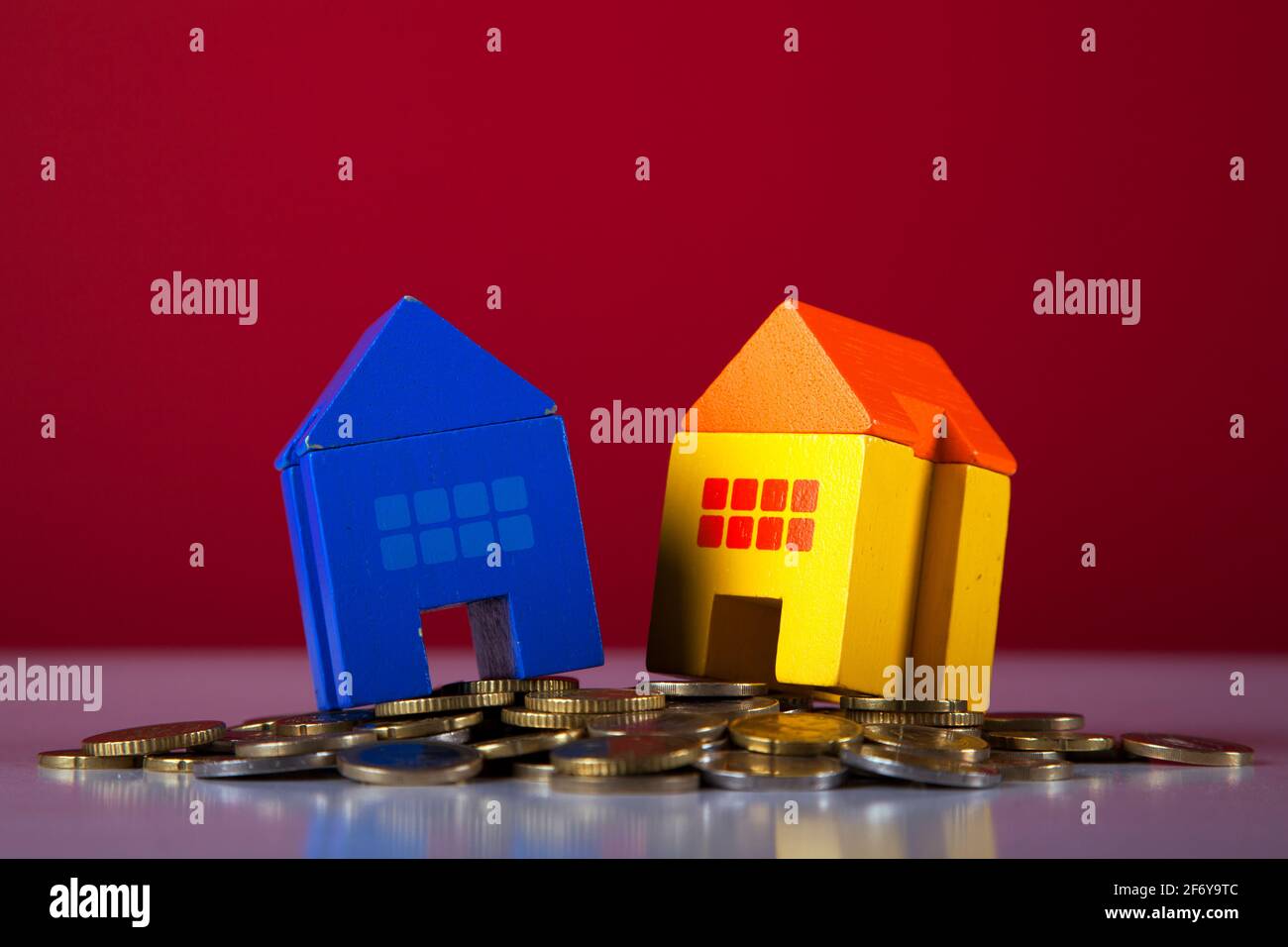 yellow toy house over a lot of golden coins Stock Photo - Alamy