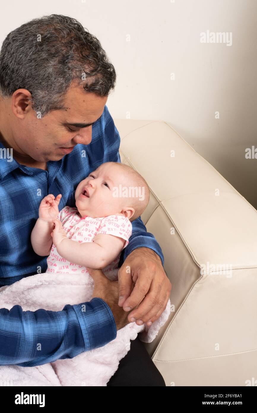Grandfather holding two month old granddaughter, fretful, crying Stock ...