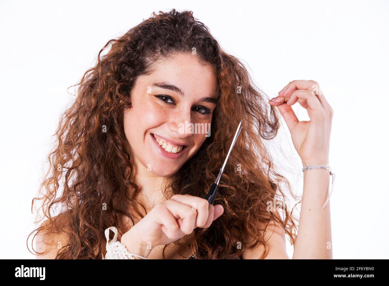 Happy young woman cutting her hair with a scissor Stock Photo - Alamy