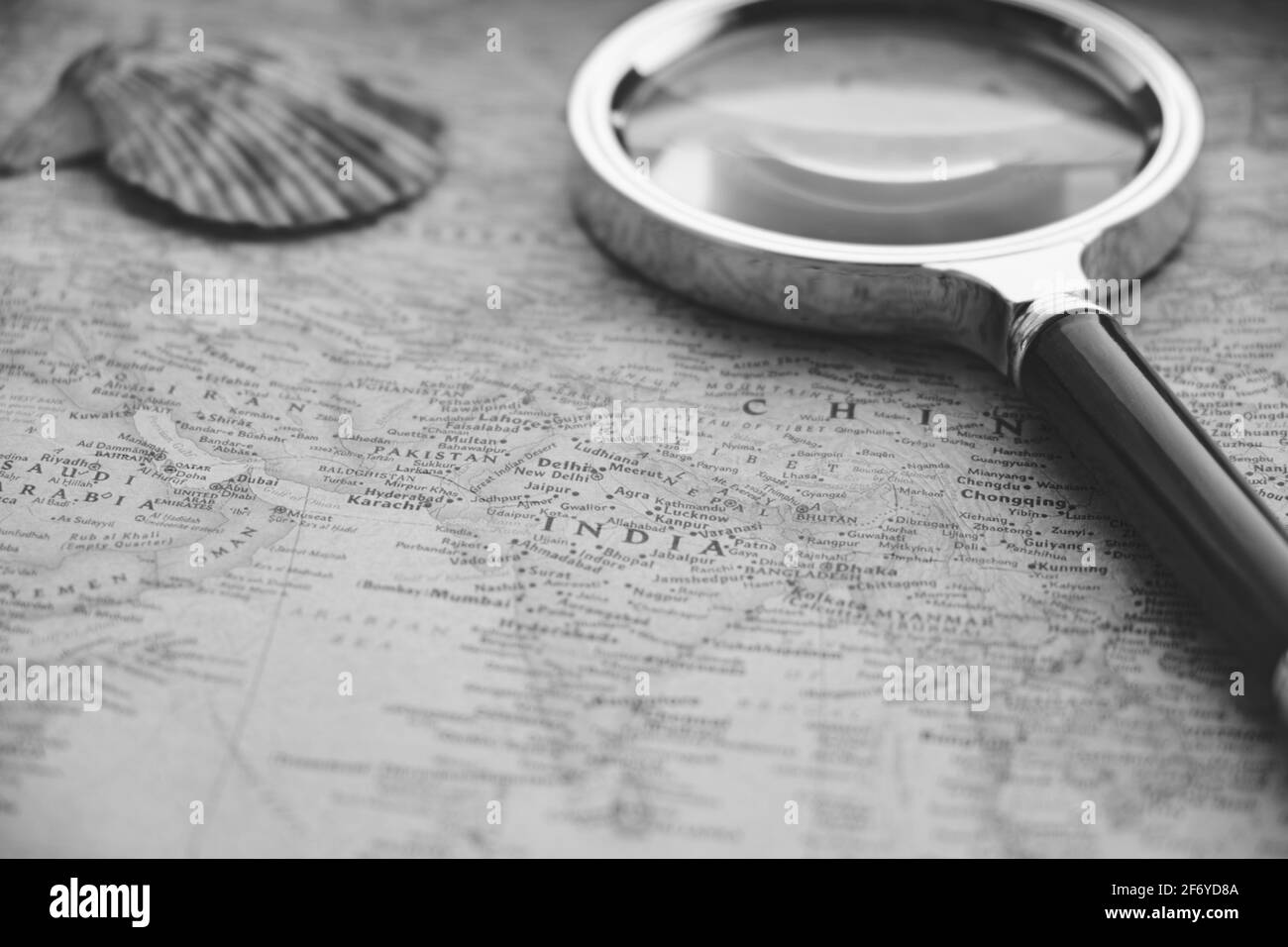 Old retro map of world is pressed with shells and magnifying glass ...