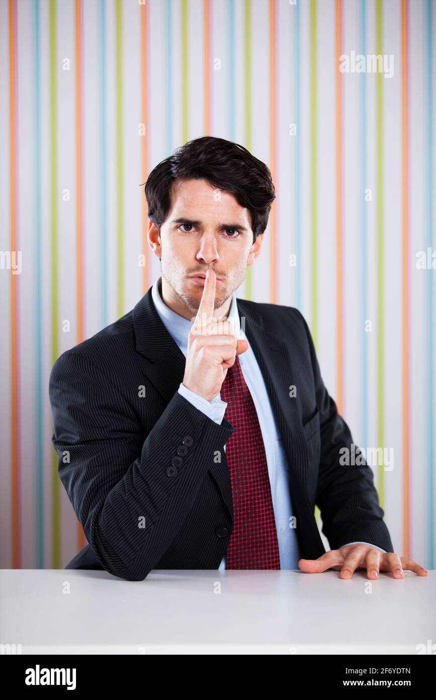 Serious male with silence hand gesture hi-res stock photography and ...