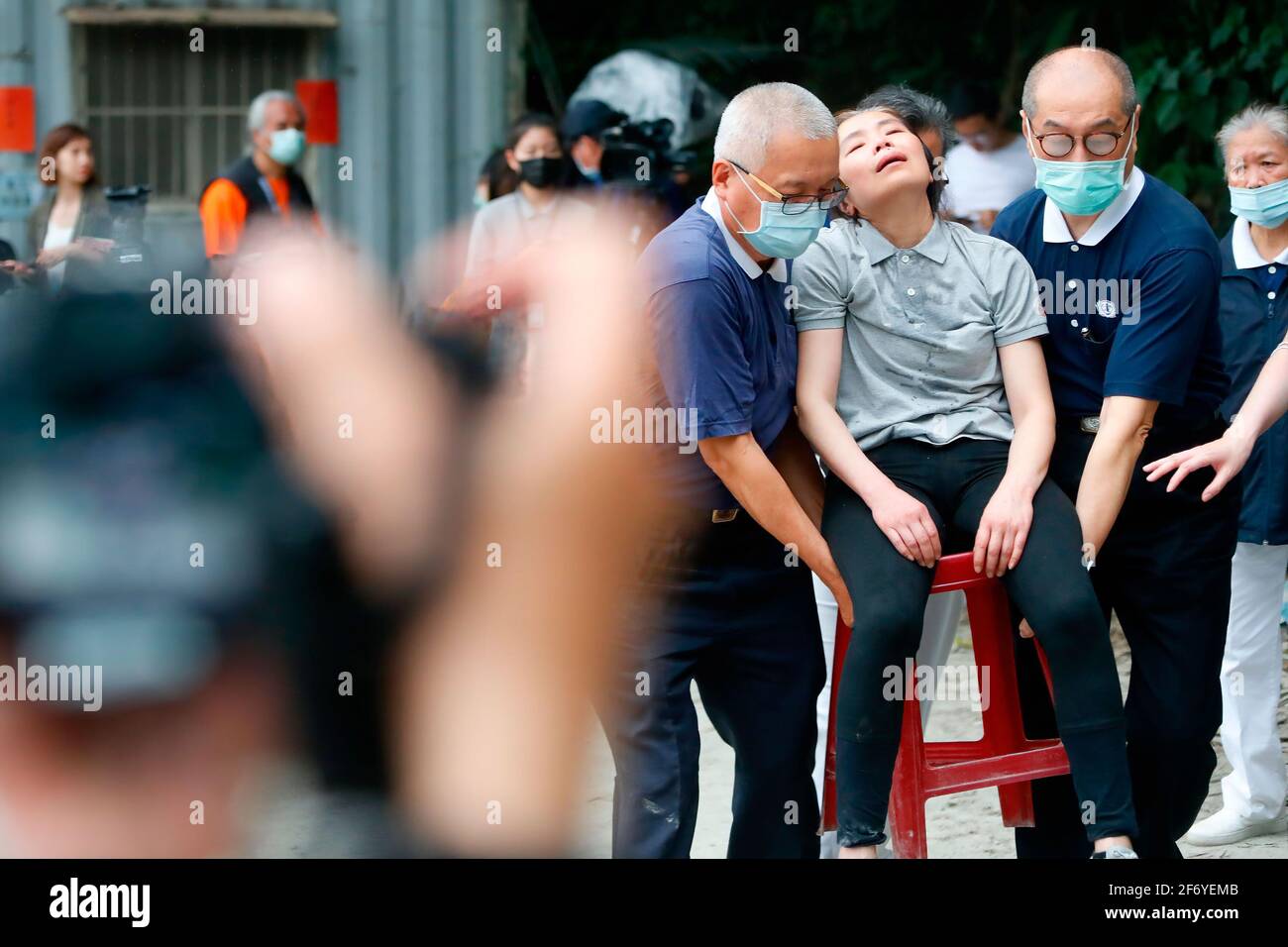 A lady faints while crying during a memorial ceremony. About a hundred ...