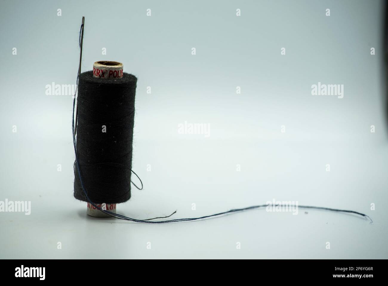 Mumbai , India - 15 March 2021, Spool of black thread with needle on a ...