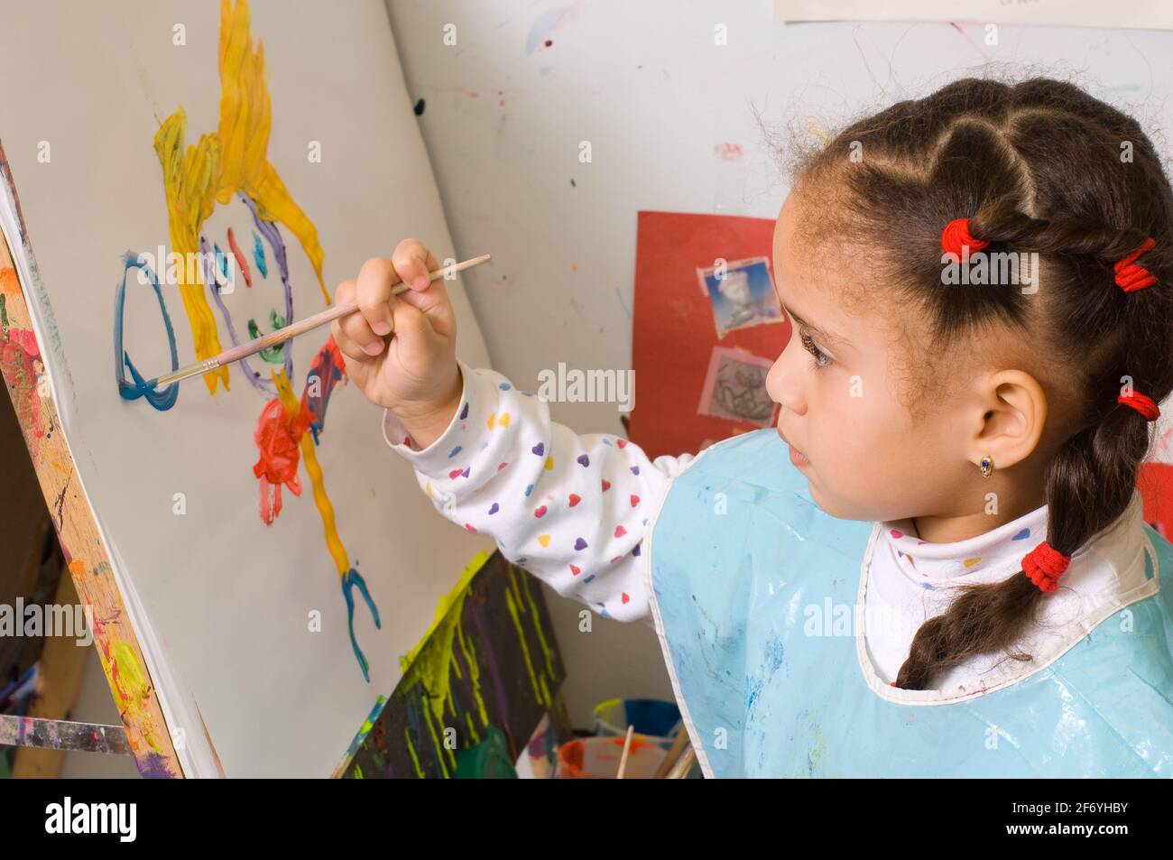 Education Preschool 3-4 year olds art activity girl in smock painting ...