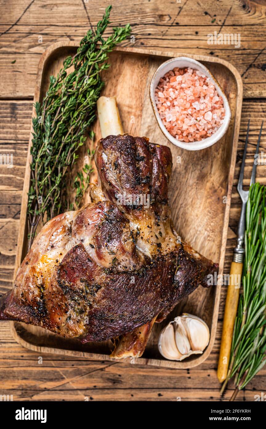 Roasted goat leg meat on a wooden cutting tray. wooden background. Top ...