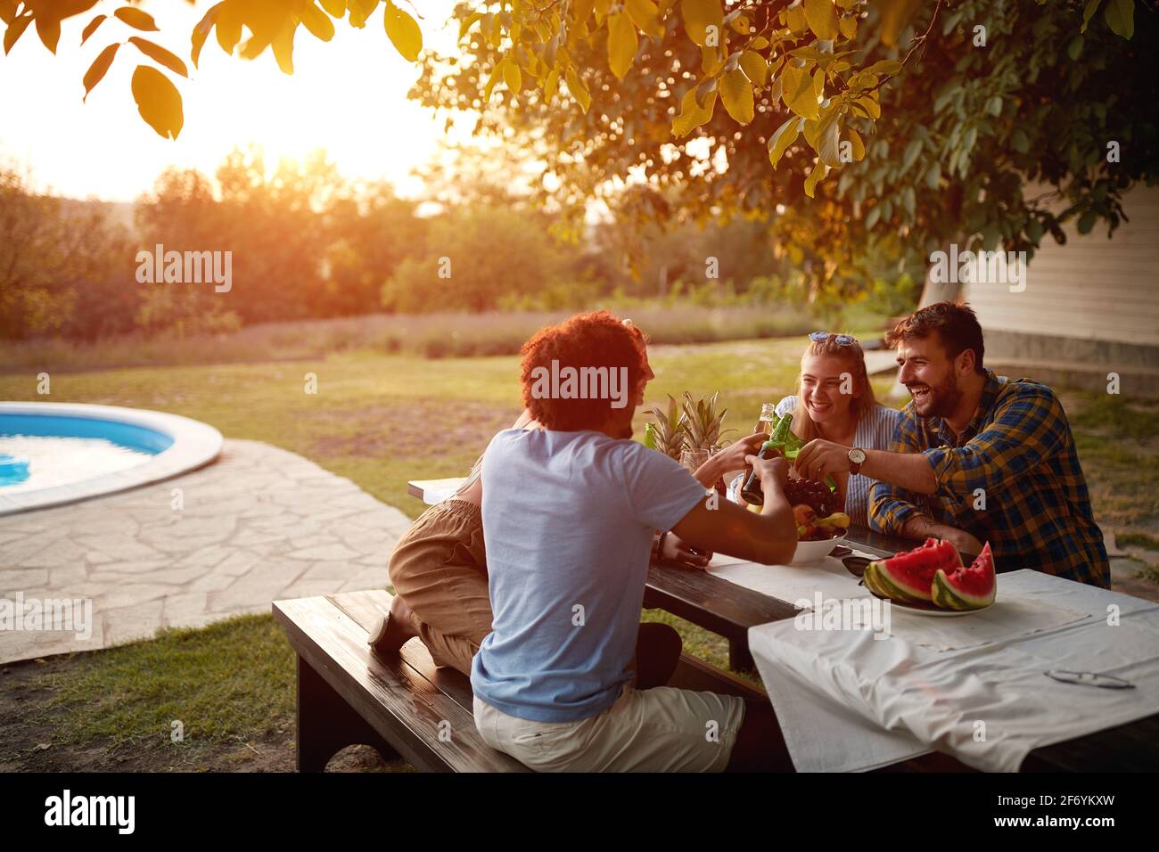 top view of friends socializing at sunset by the swimming pool outdoor ...