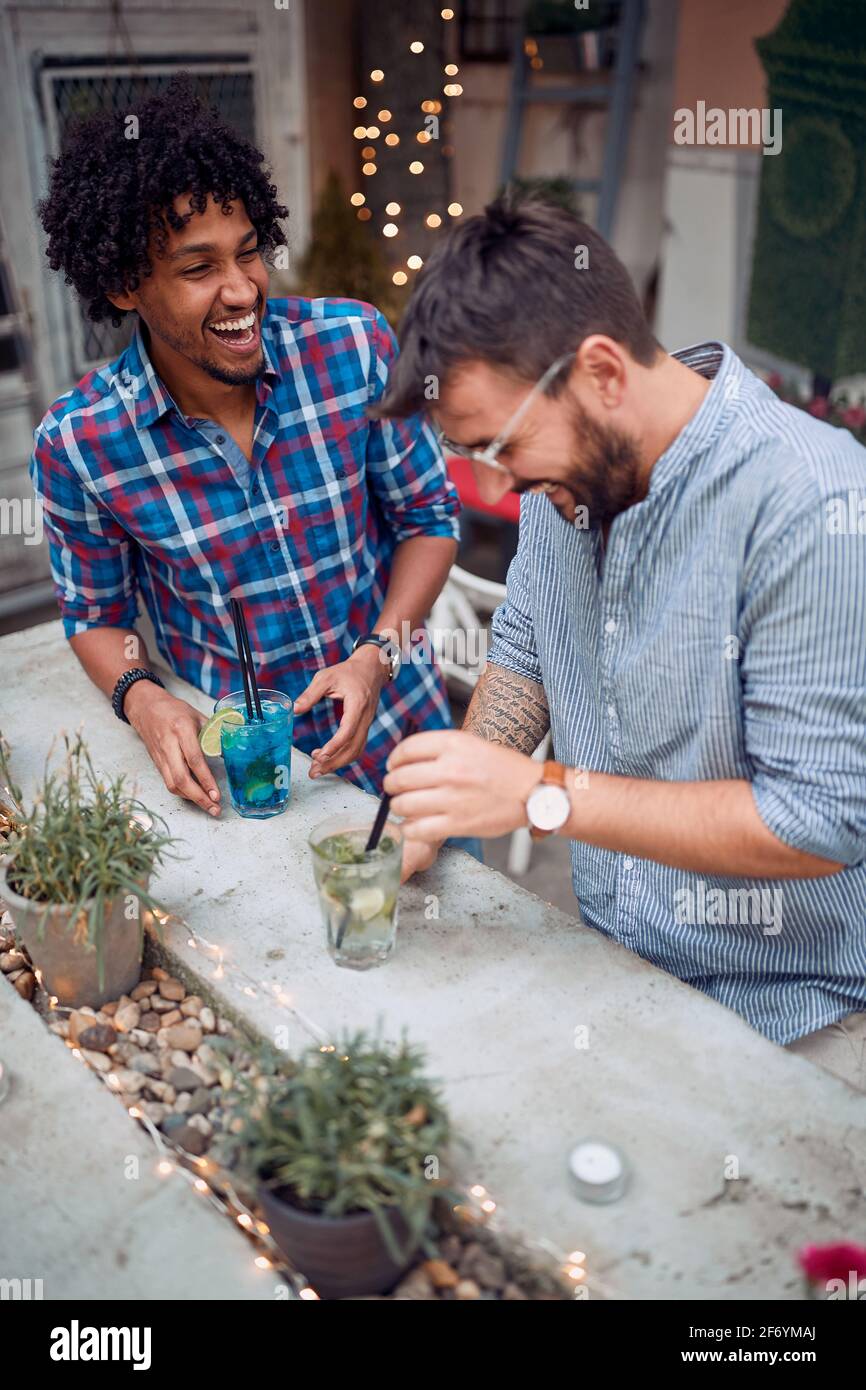 Male friends having a good time at the bar's backyard on a beautiful ...