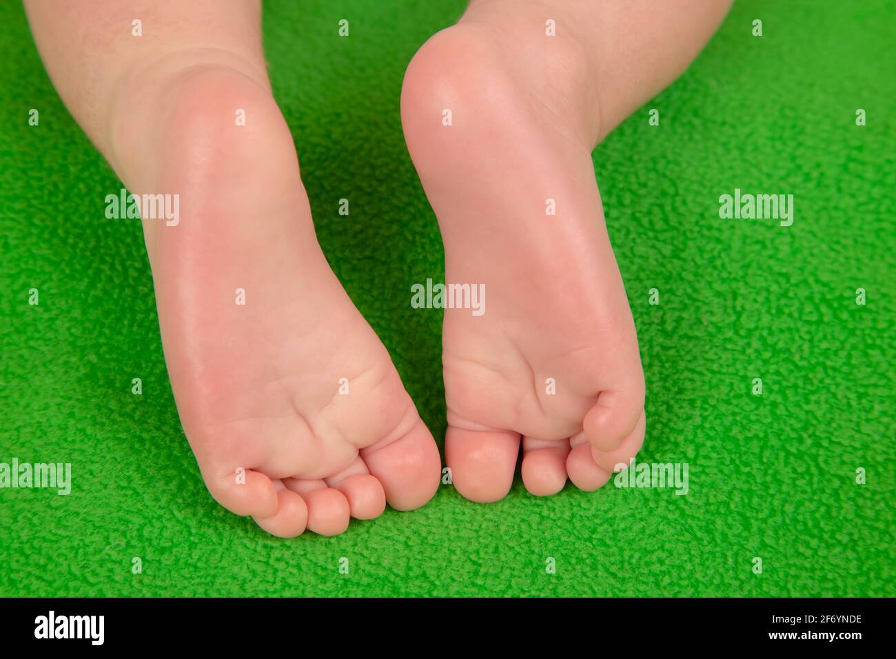 Newborn baby's feet close-up on soft tissue Stock Photo - Alamy
