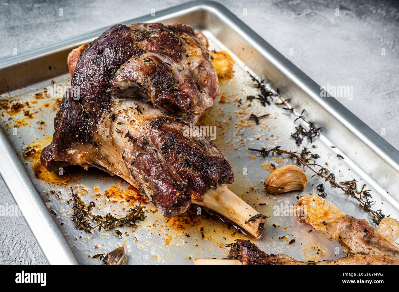 Roasted lamb mutton whole leg in a baking dish. White background. Top ...