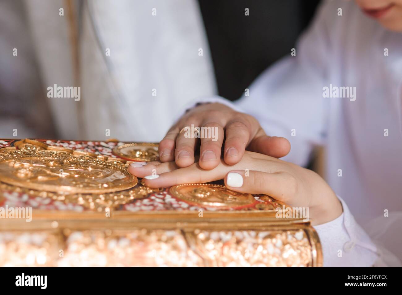 Hands of the bride and groom on the Bible. Church wedding ceremony ...