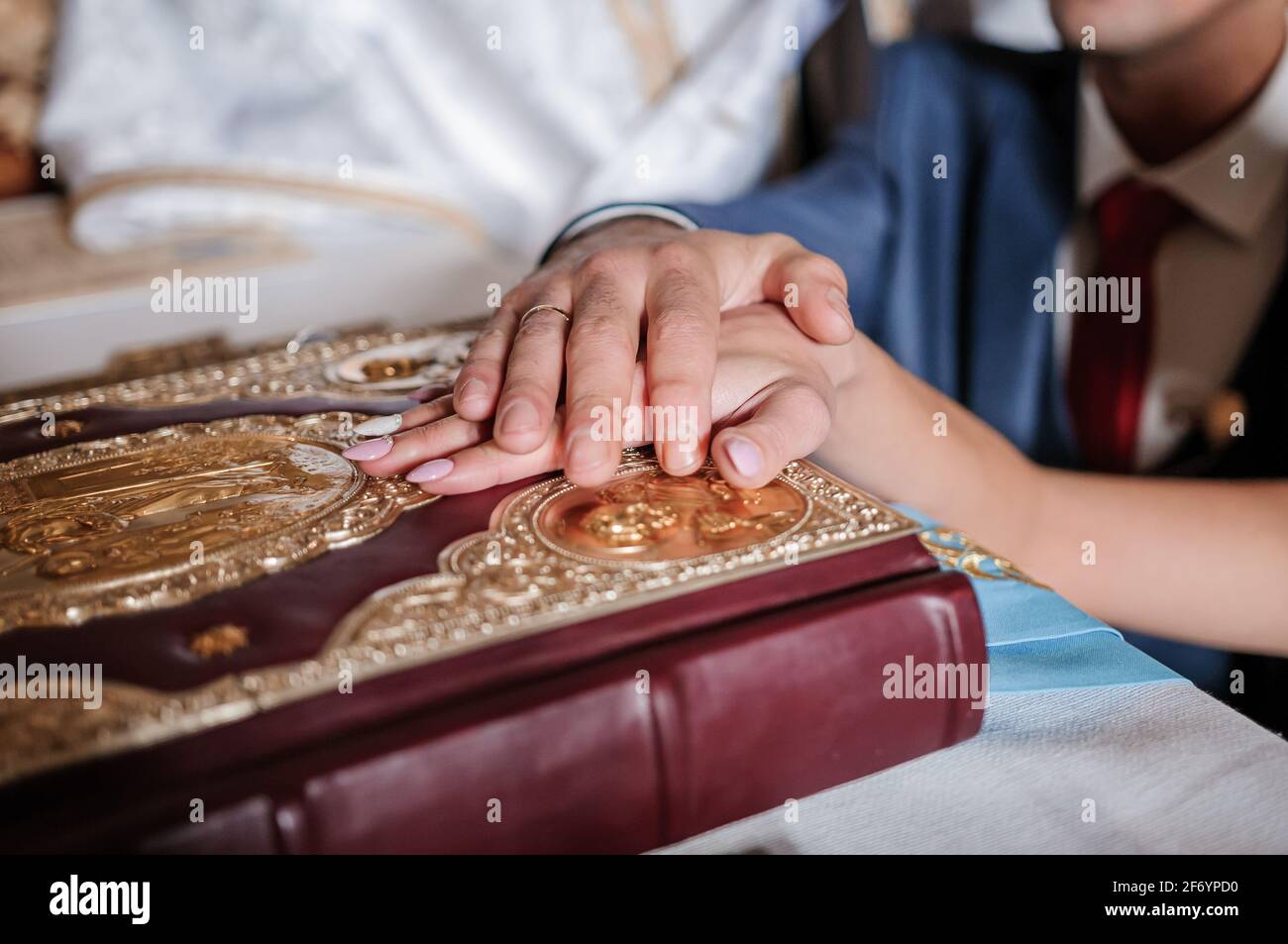Hands of the bride and groom on the Bible. Church wedding ceremony ...