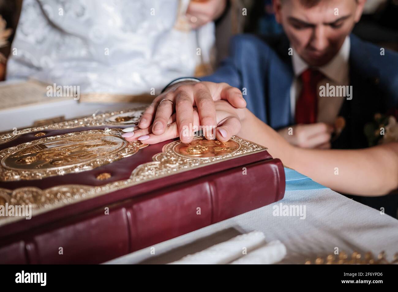 Hands of the bride and groom on the Bible. Church wedding ceremony ...