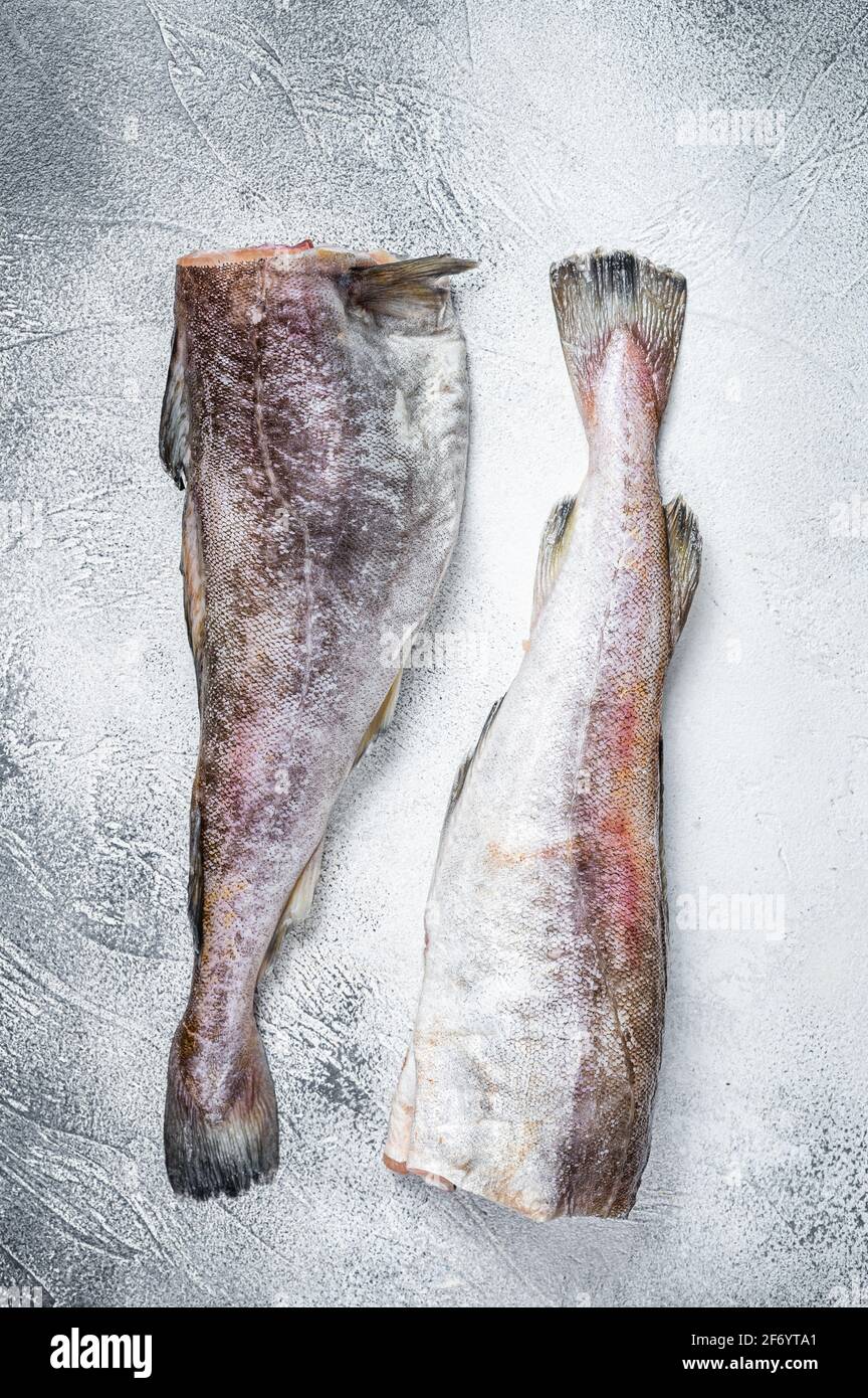 Raw cod whole fish on kitchen table. White background. Top view Stock ...