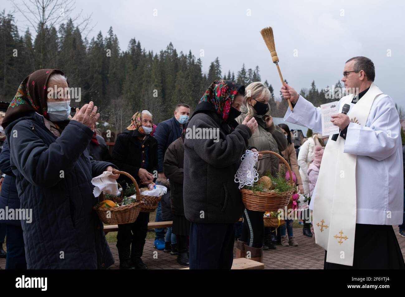 A priest seen blessing the food on the Holy Saturday.Traditional ...