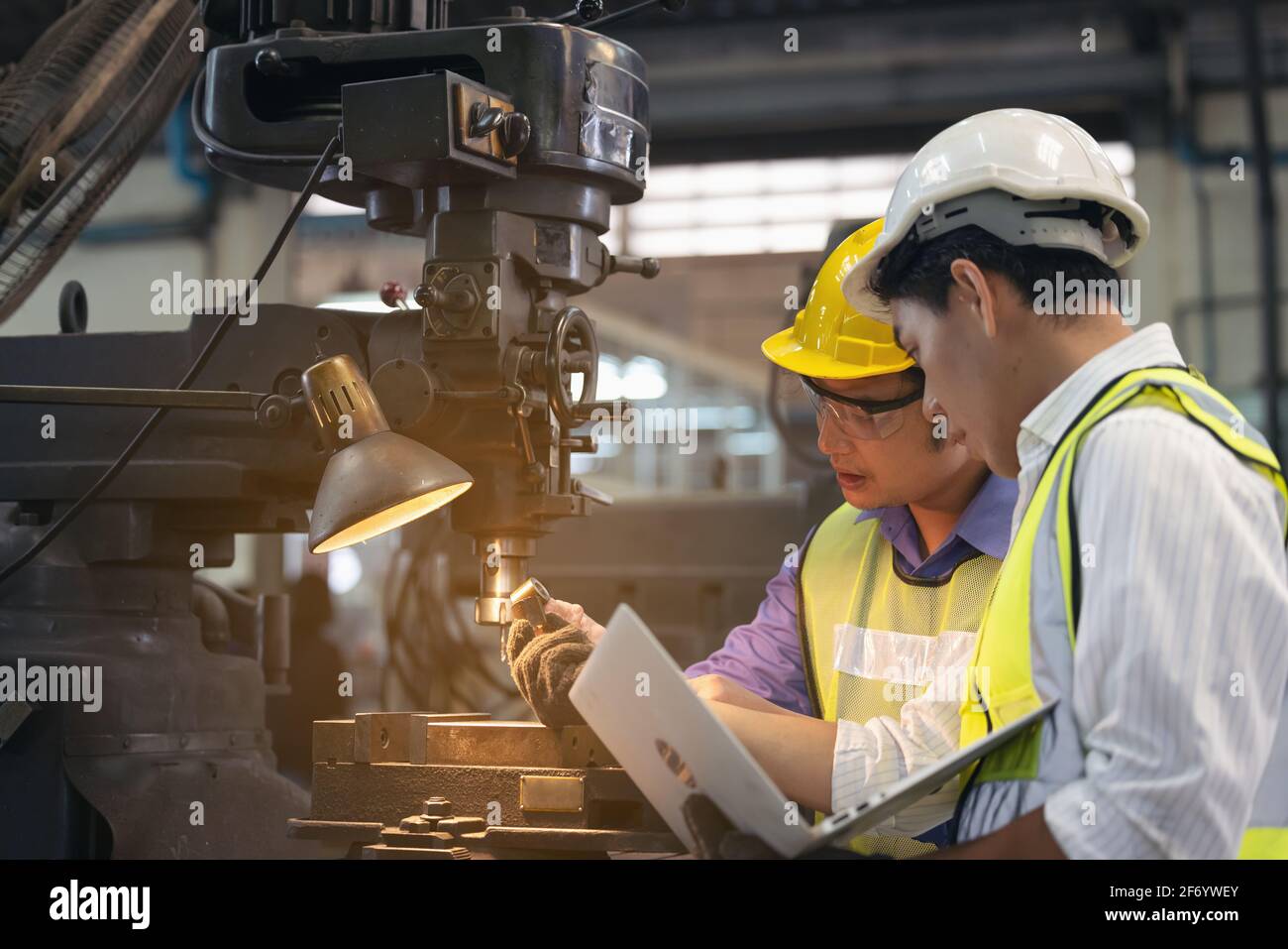 Two workers in production plant as team discussing, industrial scene in ...