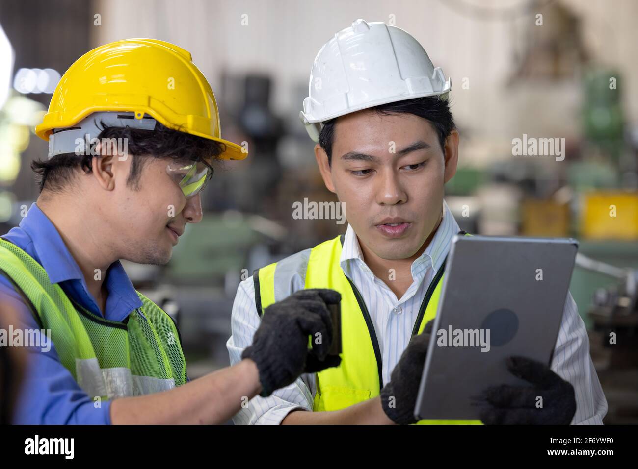 Two workers in production plant as team discussing, industrial scene in ...