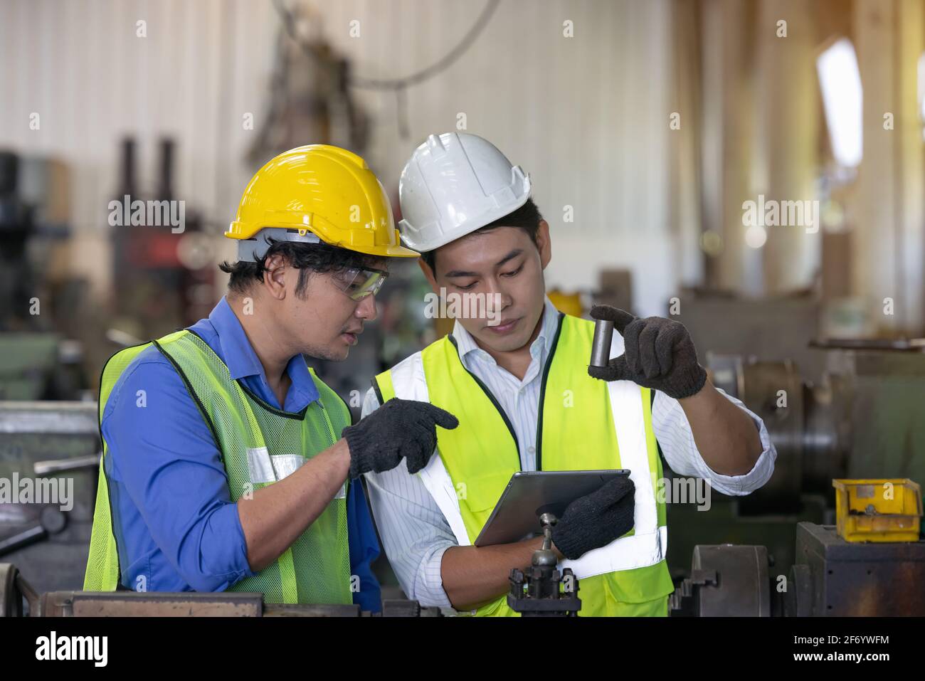 Two workers in production plant as team discussing, industrial scene in ...