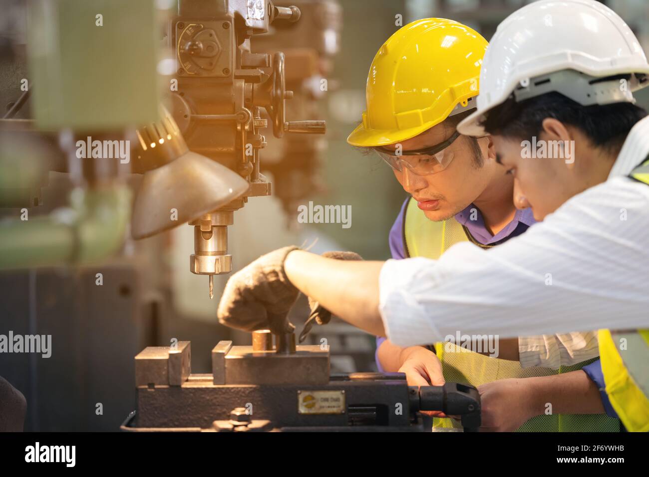 Two workers in production plant as team discussing, industrial scene in ...