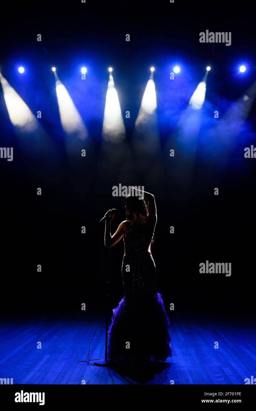 Singing woman silhouette with smoke background on the stage Stock Photo ...