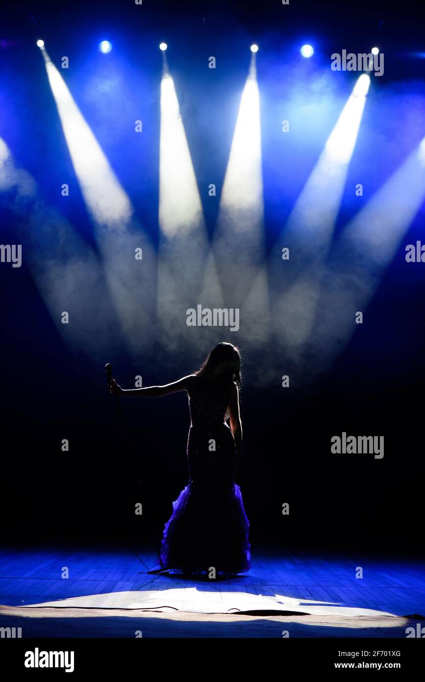 A young woman singer on stage during a concert Stock Photo - Alamy