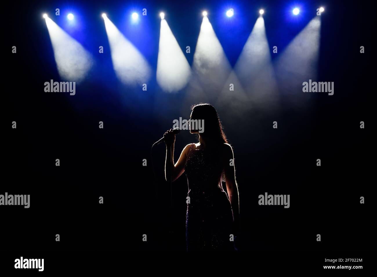 Female singer on the stage holding a microphone Stock Photo - Alamy