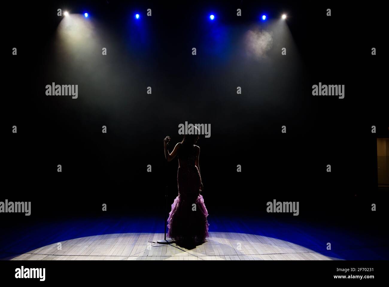 Female singer on the stage holding a microphone Stock Photo - Alamy