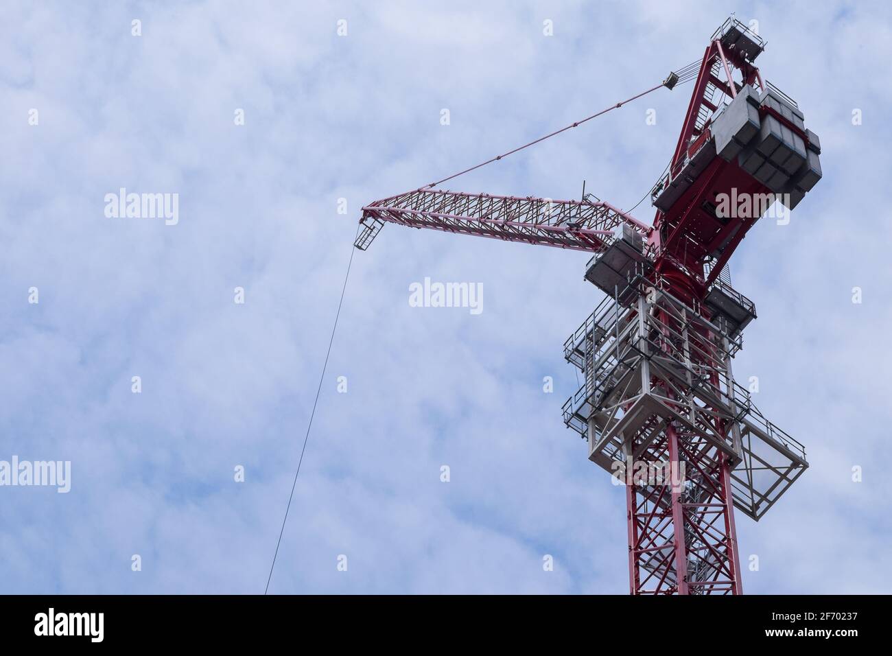 Very high hoisting crane used for building skyscrapers against a cloudy ...