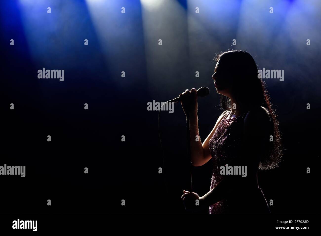 Singer woman on stage. Female singer on the stage holding a microphone ...