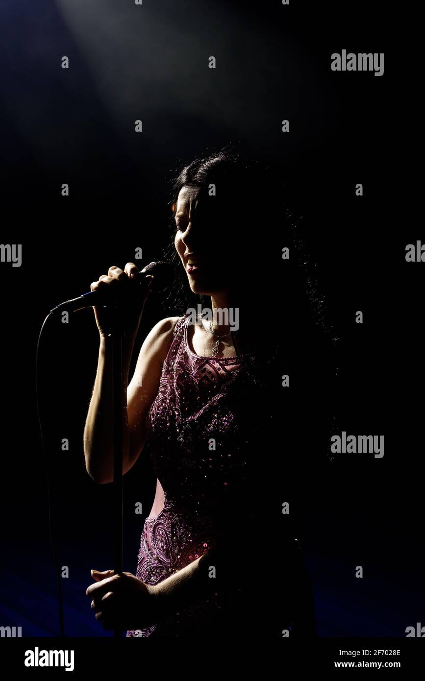 Singer woman on stage. Female singer on the stage holding a microphone ...