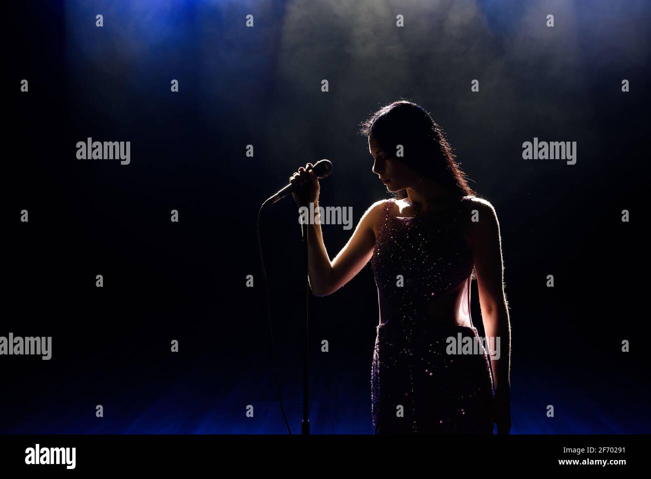 Singer woman on stage. Female singer on the stage holding a microphone ...