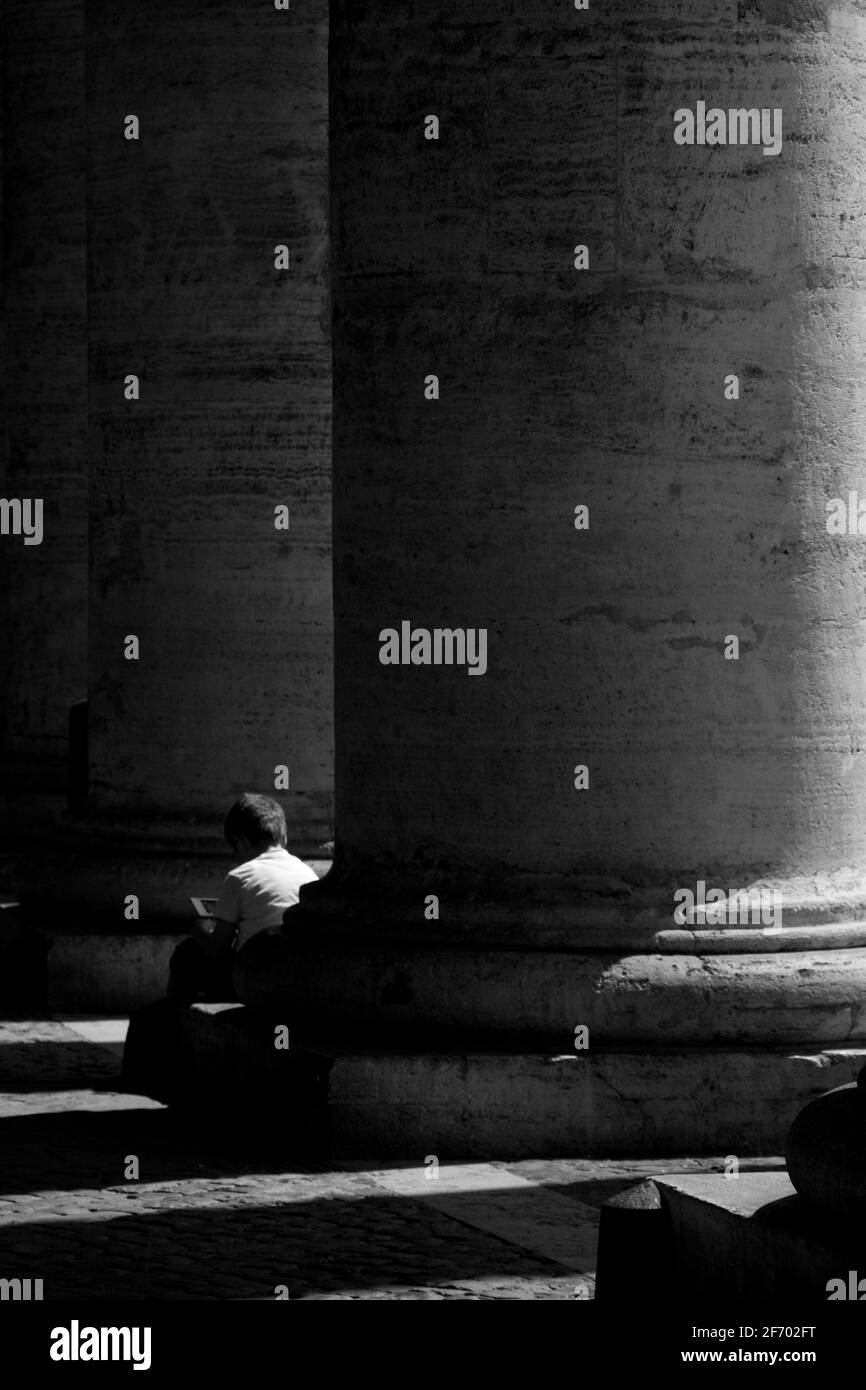 Boy sitting in a stone column Stock Photo - Alamy
