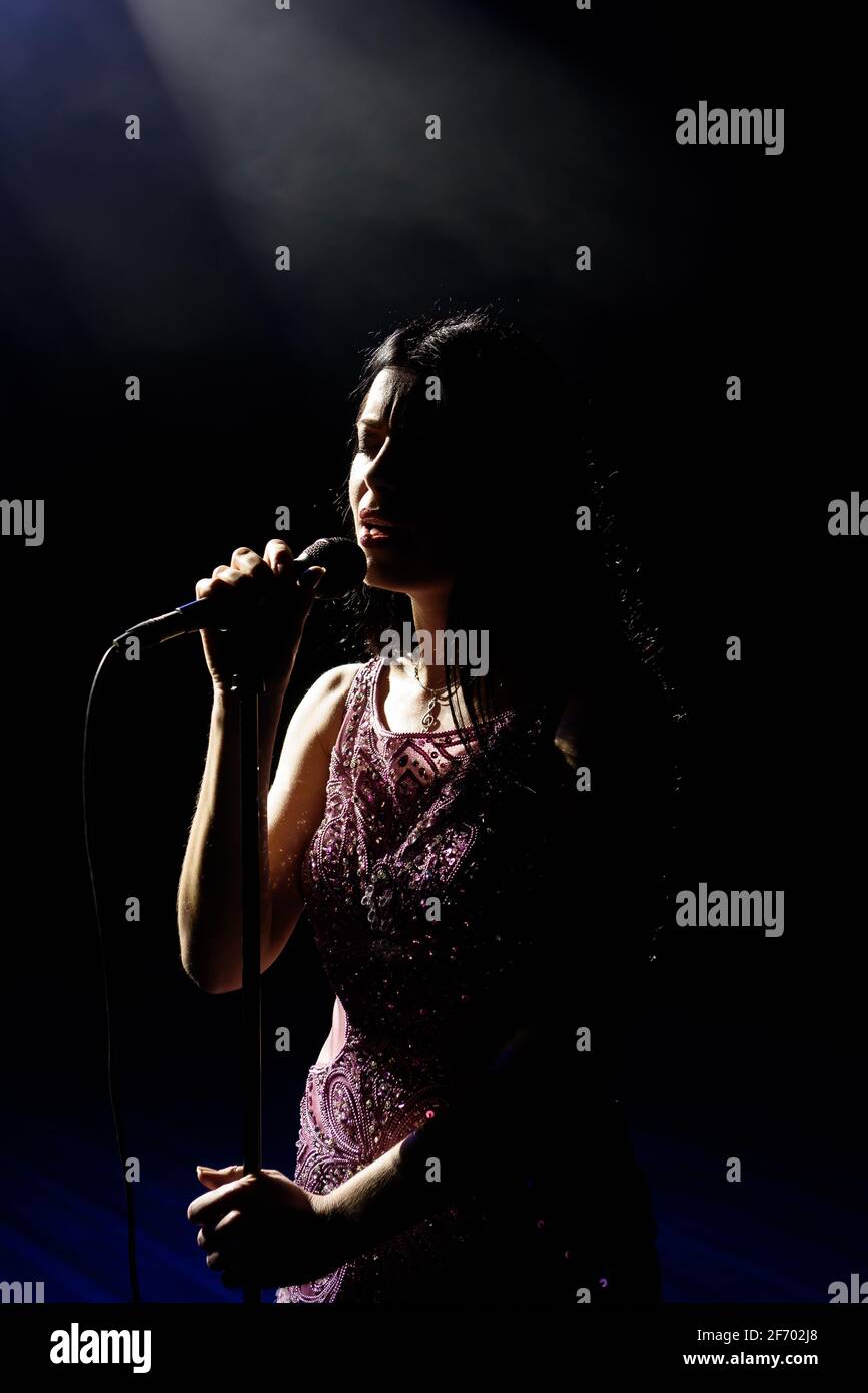 Portrait of beautiful singing woman on dark background Stock Photo - Alamy